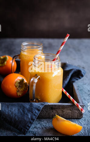 Fruit juice. Persimmon Juice (Diospyros kaki L.)> Aged wood background ...