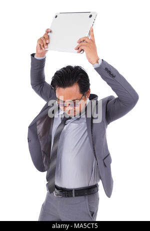 Portrait of an angry furious man throwing his laptop computer isolated ...