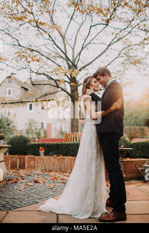 Couple in wedding day hug in green meadow Stock Photo - Alamy