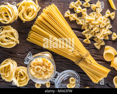 Different pasta types on wooden table. White background Stock Photo - Alamy