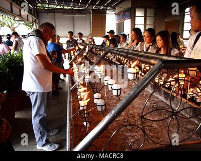 Asian female tourist praying with Virgin Mary statue at Merizo Bell ...