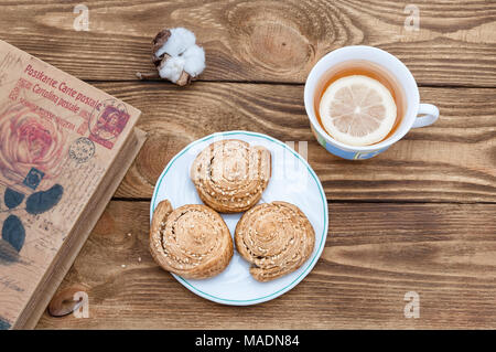 book, lemon, tea and cookies on table at home Stock Photo - Alamy