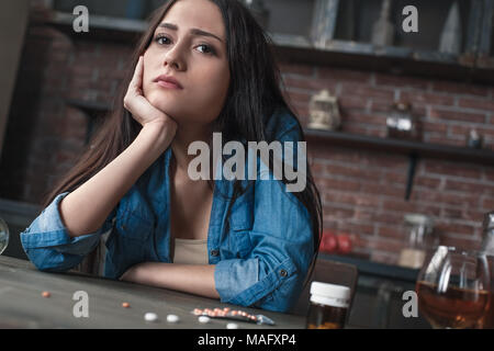 Young female drug addicted social problems sitting at table sniffing ...