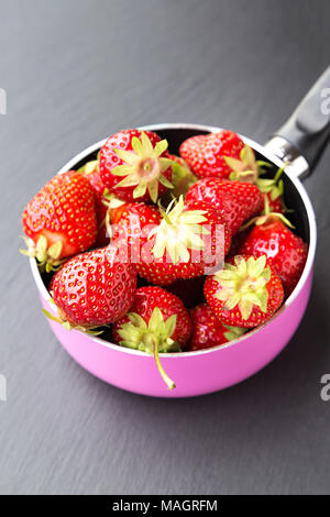 Pink pot with green juicy grass on the office desk Stock Photo - Alamy