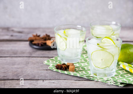 homemade lemonade with lime, anise, cinnamon and ice on a wooden ...