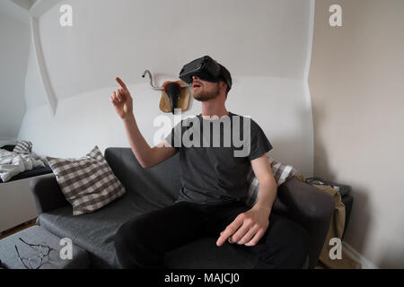 Male on a sofa enjoying a virtual reality experience Stock Photo - Alamy