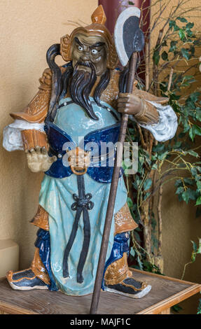 A fierce looking Chinese temple guardian statue at the entrance to the ...