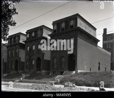 Facade of three-story residential buildings with a brick facade and a ...