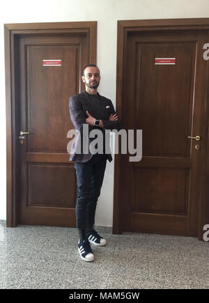 Undertaker in front of black funeral hearse leaving housing estate in ...