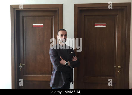 Undertaker in front of black funeral hearse leaving housing estate in ...