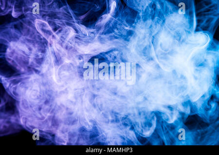 Dense multicolored smoke of blue colors on a black isolated background ...