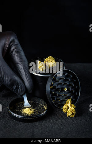 A medicinal marijuana grinder with keef and scraper. a hand with a ...