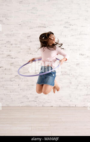 Girl jumping with hula hoop Stock Photo - Alamy