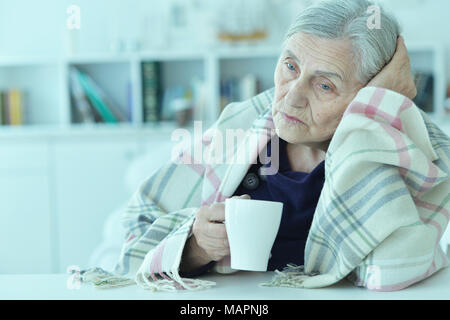Sad old woman with headache drinking tea Stock Photo - Alamy