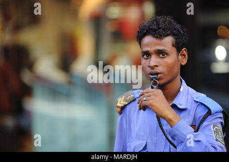 Portrait of Security guard blowing whistle and gesturing with palm ...