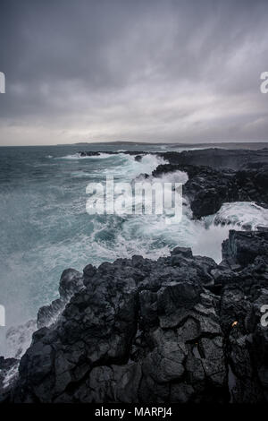 Rugged Icelandic coastline with big waves hitting the black rocks at ...