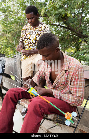 Men craft beadwork souvenirs in Harare, Zimbabwe. The men ply their ...