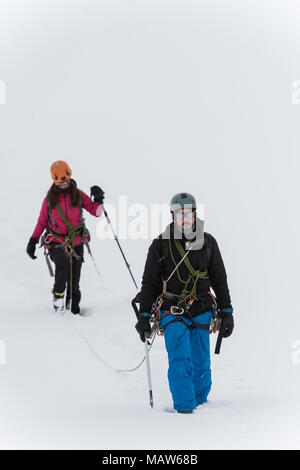 Couple walking with harness on a snow capped mountain Stock Photo - Alamy