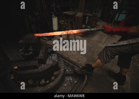 Blacksmith shaping hot metal rod in machine Stock Photo - Alamy