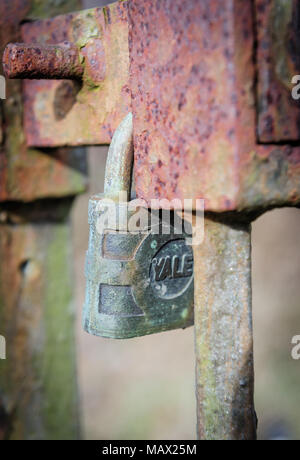 Rusting padlock securing a gate on private land in South Wales Stock ...