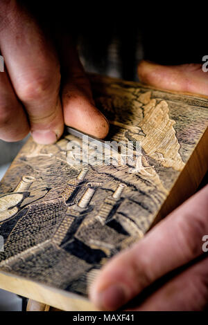 Craftsman Keith Pettit working on one of his wood engravings depicting ...
