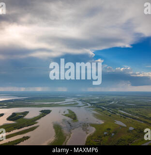 Rain comes from thunderclouds over the Great plain river in summer, the ...