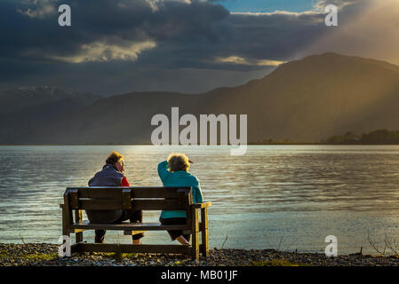 A couple enjoying a waterside seat at sunset Stock Photo - Alamy