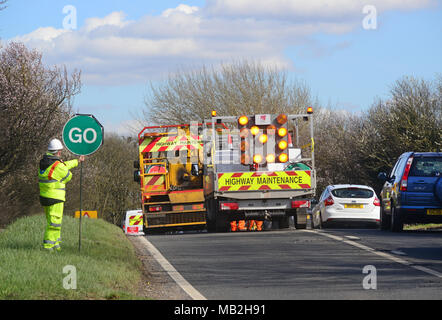 stop go sign and workers at road works Stock Photo - Alamy