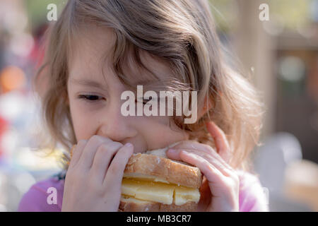 Young girl eating cheese sandwich Stock Photo - Alamy