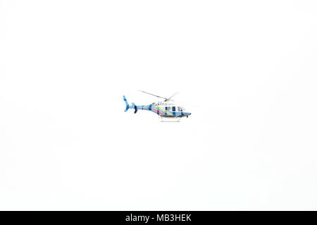 National Grid Blue and white helicopter in flight against a blue sky ...