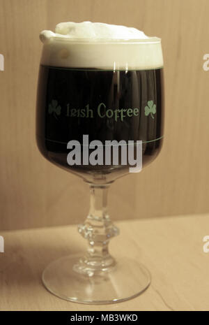 Coffee with Irish whiskey and whipped cream in glass on rustic wooden ...