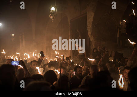 Orthodox Christian worshipers hold candles lit with miraculous lighting ...