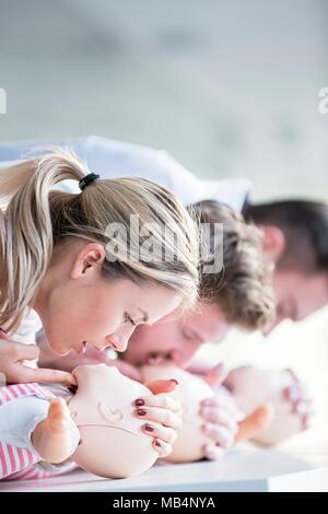 MODEL RELEASED. Doctor practising infant CPR on training dummies Stock ...