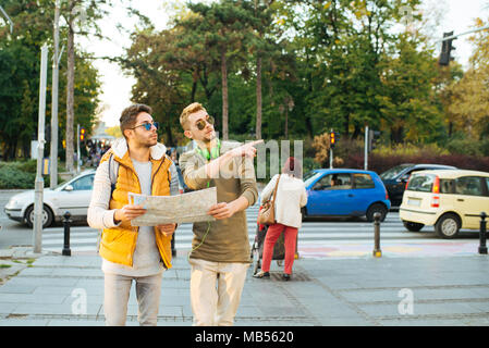 Young happy tourists holding map sightseeing in city Stock Photo - Alamy
