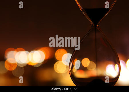 Hourglass over bokeh city lights as time passing concept for business ...