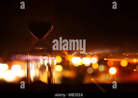 Hourglass over bokeh city lights as time passing concept for business ...