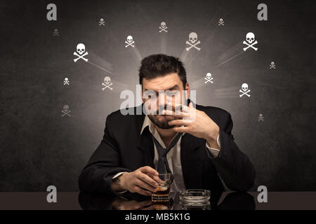 Loser drunk man sitting at table with skulls concept around Stock Photo ...