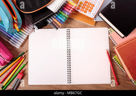 Busy student's desk with open notebook, school bag, text books and ...
