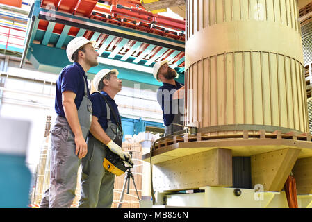 group worker assembles a transformer in mechanical engineering ...