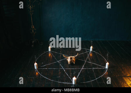 Candles on a pentagram on the wooden floor. magical ritual with occult ...