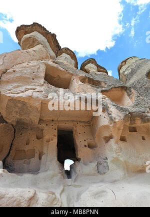 The volcanic landscape of cone shaped rock, carved caves and dwellings ...