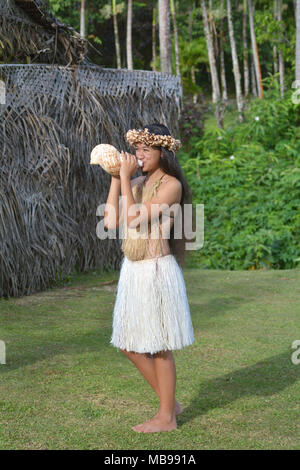 Topless polynesian woman blowing a conch shell horn Stock Photo - Alamy