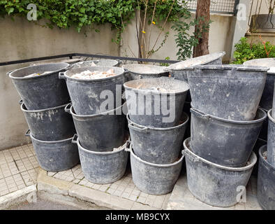 Pile of plastic construction buckets on construction site background ...