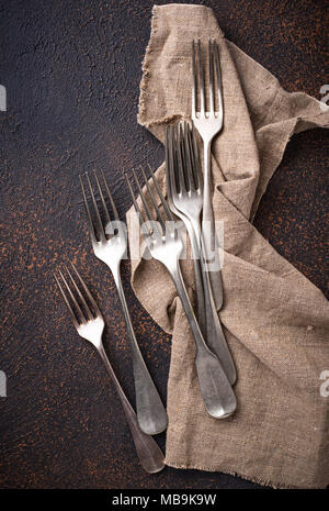 Very old rusty vintage silver fork on a black cement texture background ...