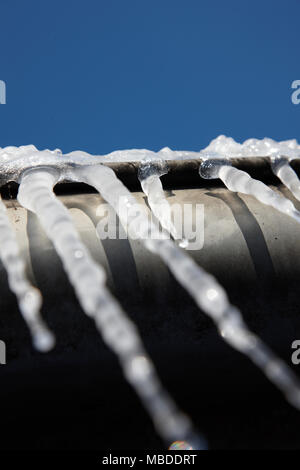 Icicle in the eaves spout with a blue sky background Stock Photo - Alamy