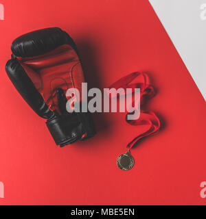 top view of boxing glove with medal and green apple on white surface ...