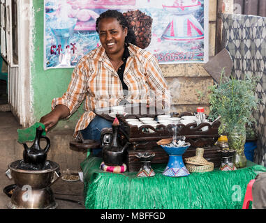 Ethiopian traditional Coffee ceremony women in traditional dress preparing bunna coffee in Addis ...