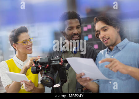 Smiling journalists and cameraman using digital camera Stock Photo - Alamy