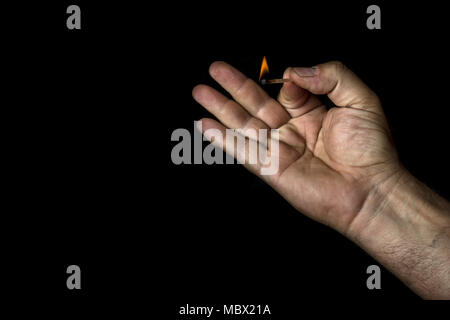 Hand holding lit match black background, studio photograph Stock Photo ...