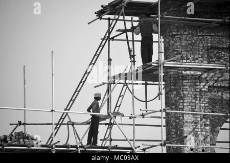 Construction workers on scaffolding lifting bars to renovate a Stock ...